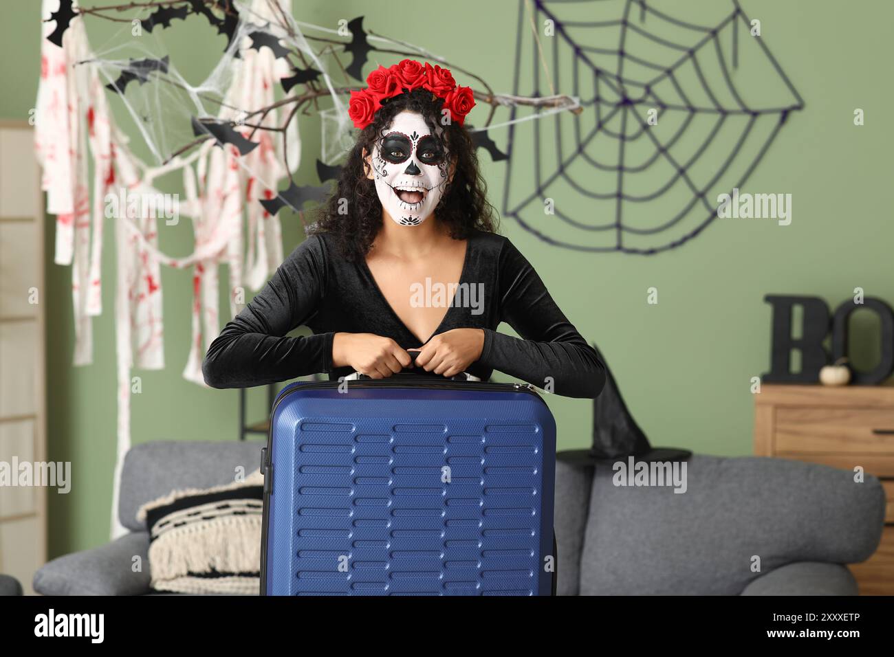 Female African-American tourist dressed for Halloween with suitcase at ...