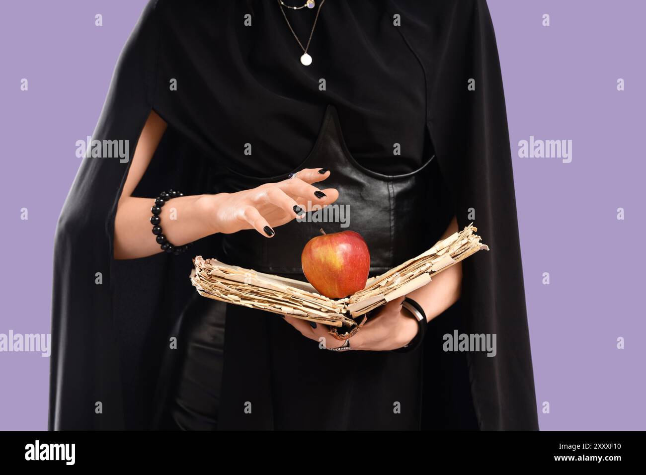 Beautiful young woman dressed as witch for Halloween with apple and ...