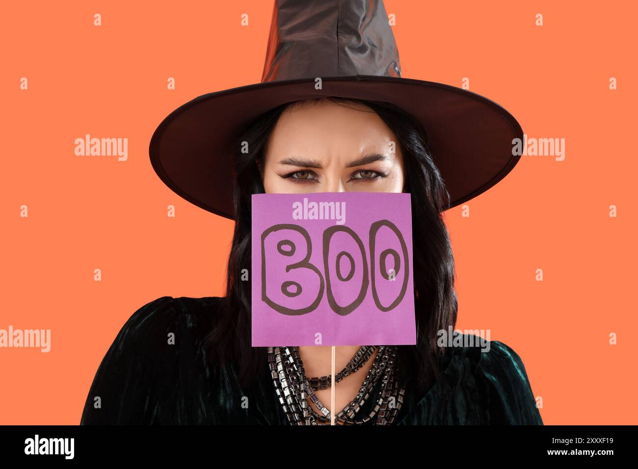 Beautiful young woman dressed as witch for Halloween with word BOO on ...
