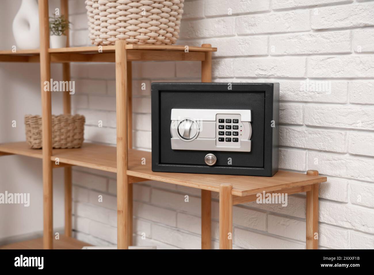 Modern safe on shelf near white brick wall Stock Photo - Alamy