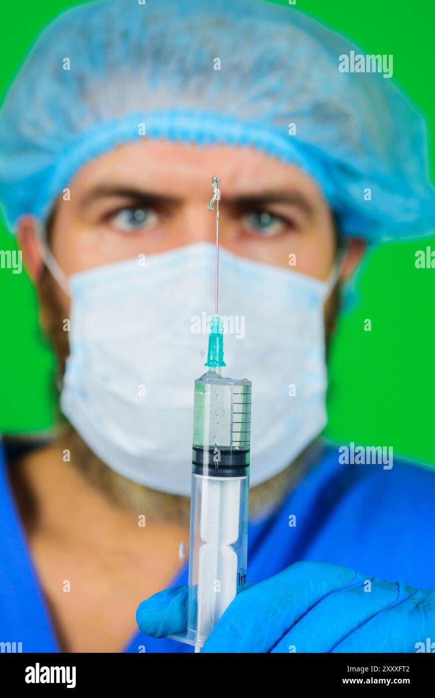 Doctor in medical mask with syringe preparing for injection. Solution ...