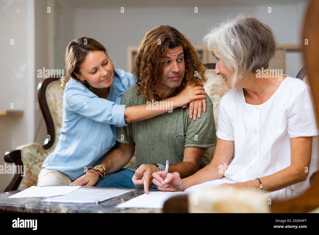Positive couple and old woman taking notes on the sofa at home Stock ...