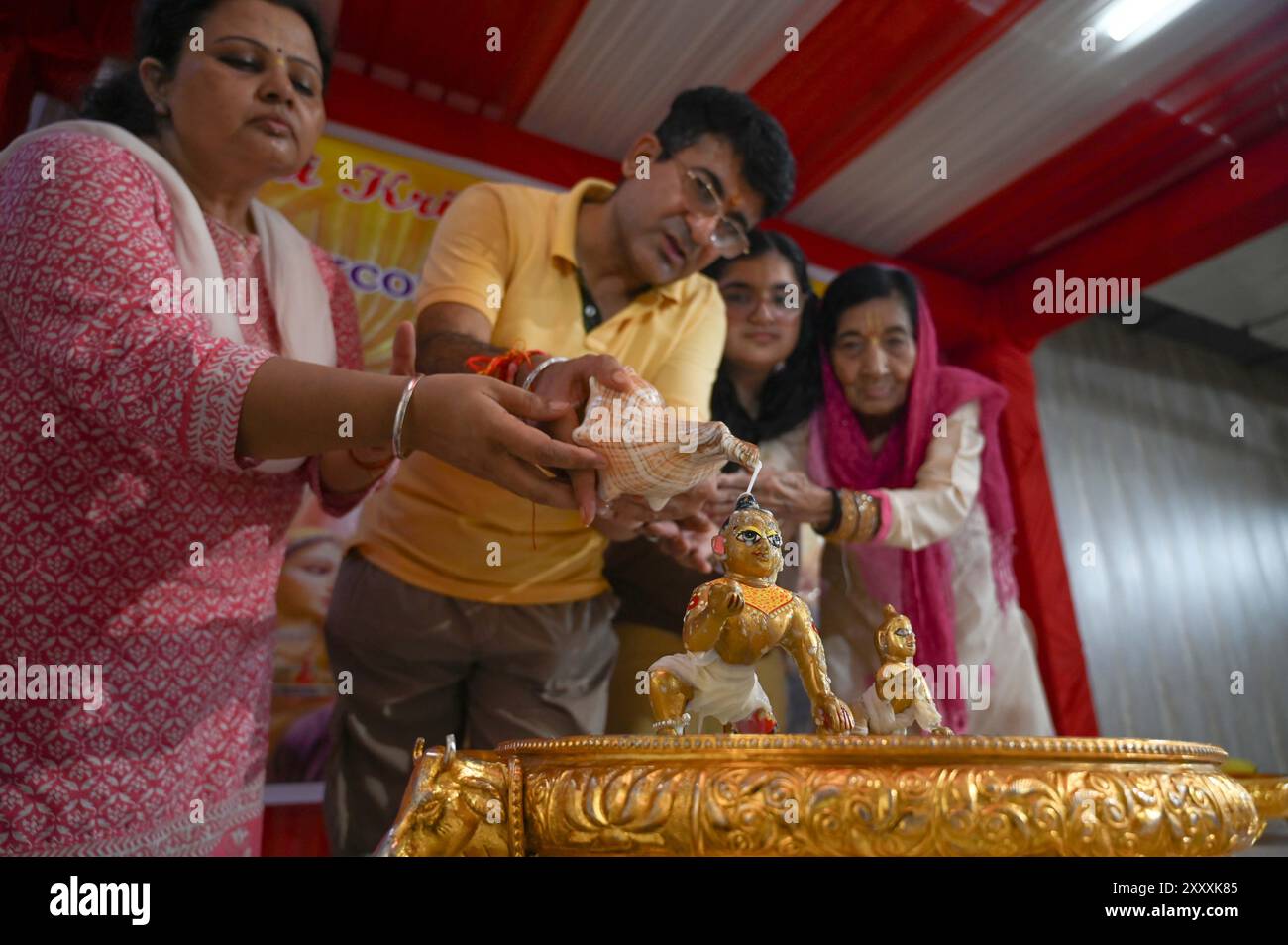 GURUGRAM, INDIA - AUGUST 26: Devotees performing Jal Abhishek of Lord Krishna during the Krishna ...