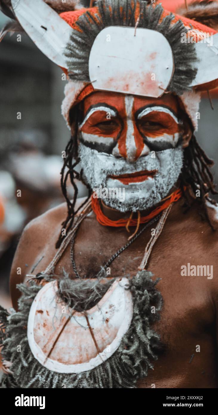 A Highland warrior of Papua New Guinea, face adorned with bold paints ...