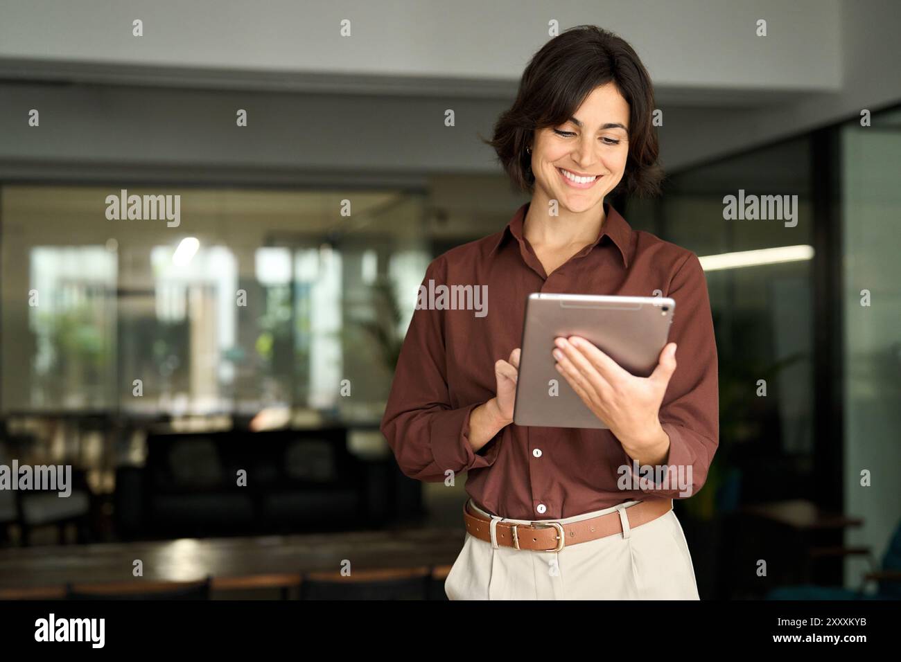 Happy busy female professional manager using tab standing in office ...