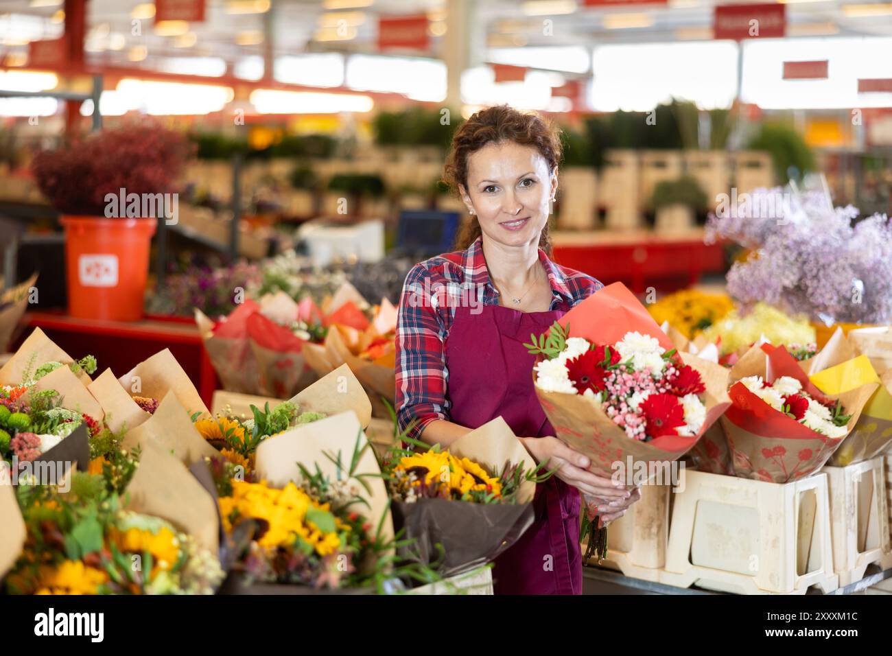 Adult female seller holding bouquet of flowers Stock Photo - Alamy