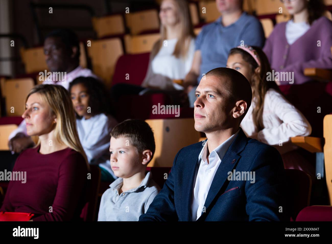 Parents with tween son watching theatrical performance in theater Stock ...