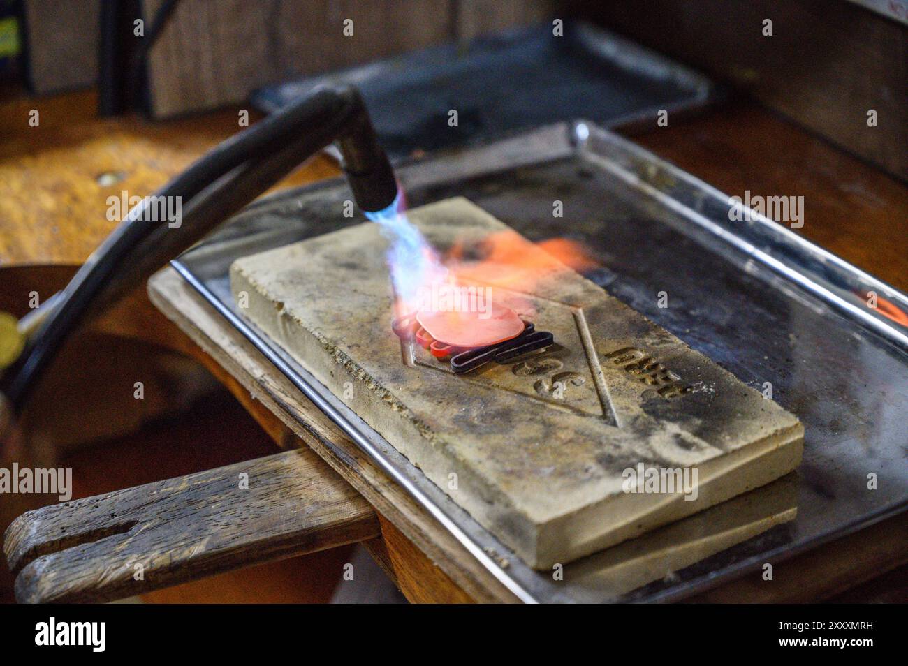 Craftsman using a blowtorch to work on a jewel in his workshop Stock ...