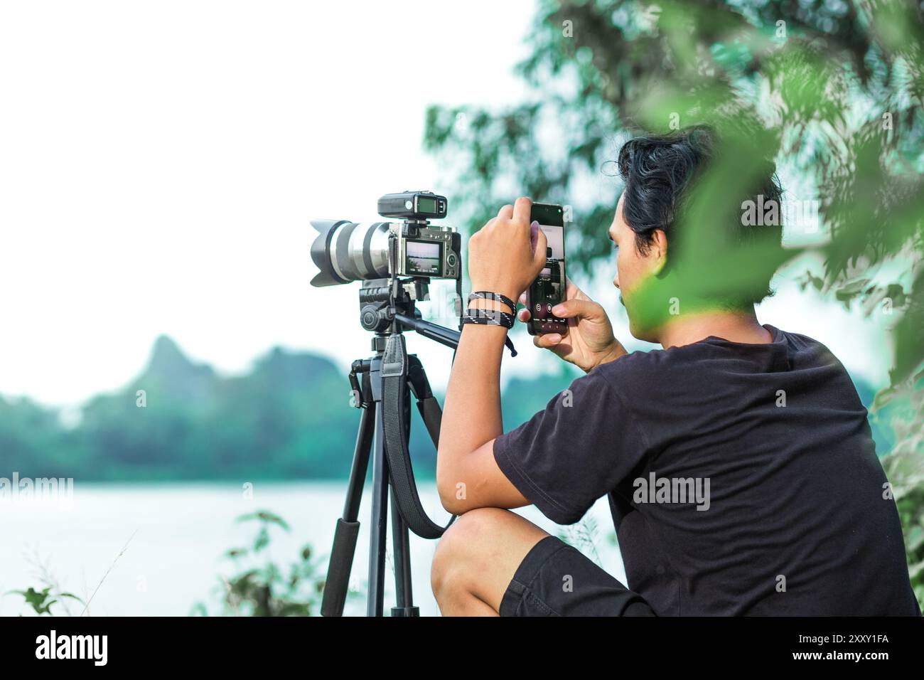Man setting camera to be connected to the phone. Man sitting on the ...