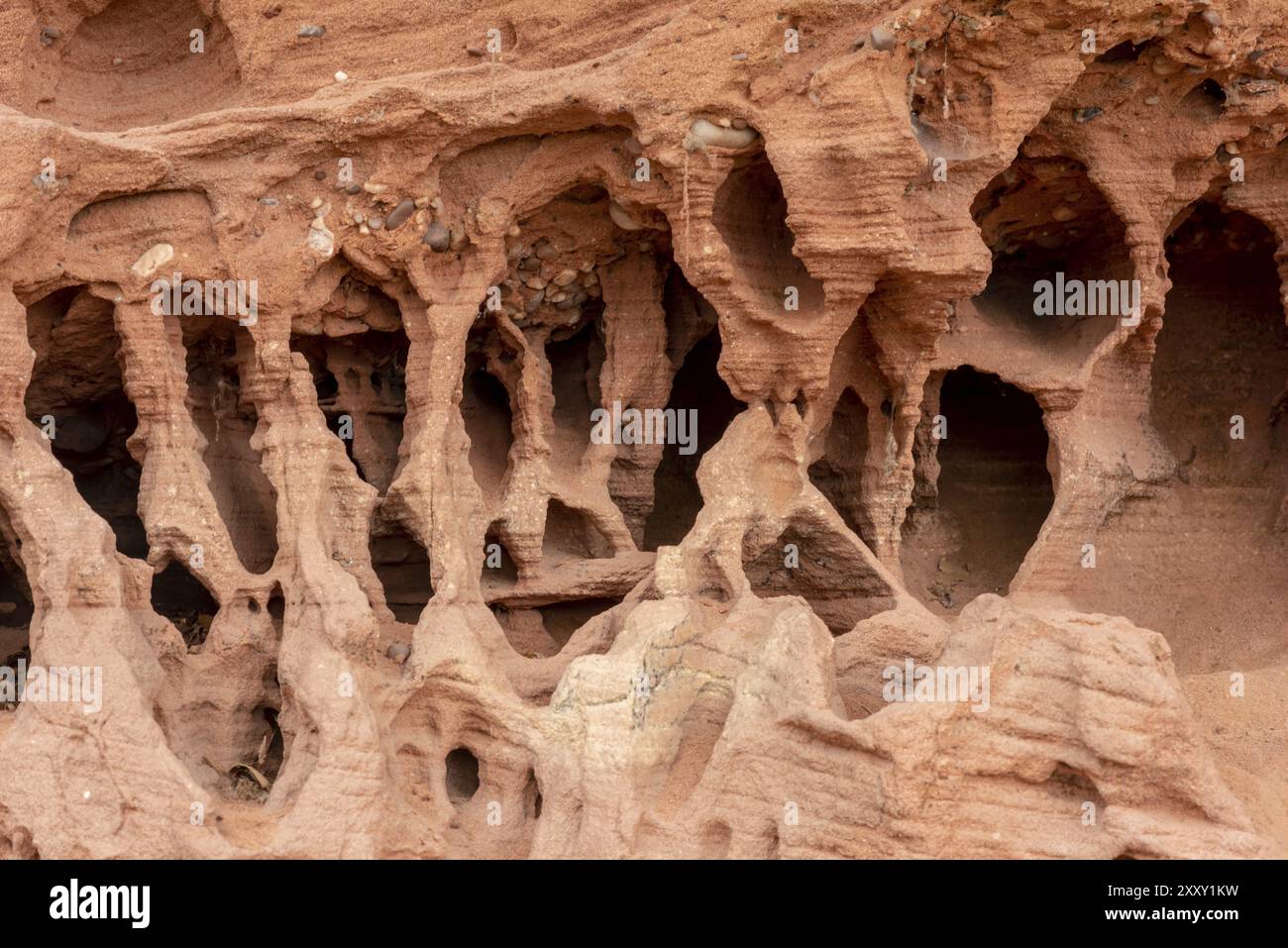 Water-washed red sandstone cliffs with deep furrows and hollows Stock ...