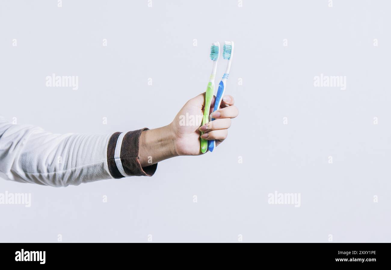 Toothbrush change concept. Hand holding two toothbrushes isolated. Oral ...