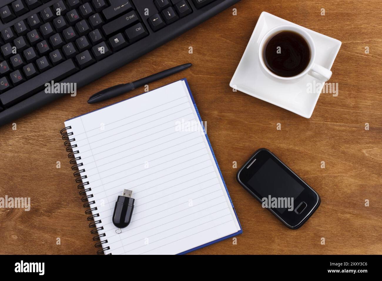 Overhead of office table with computer keyboard, mouse, phone, USB ...