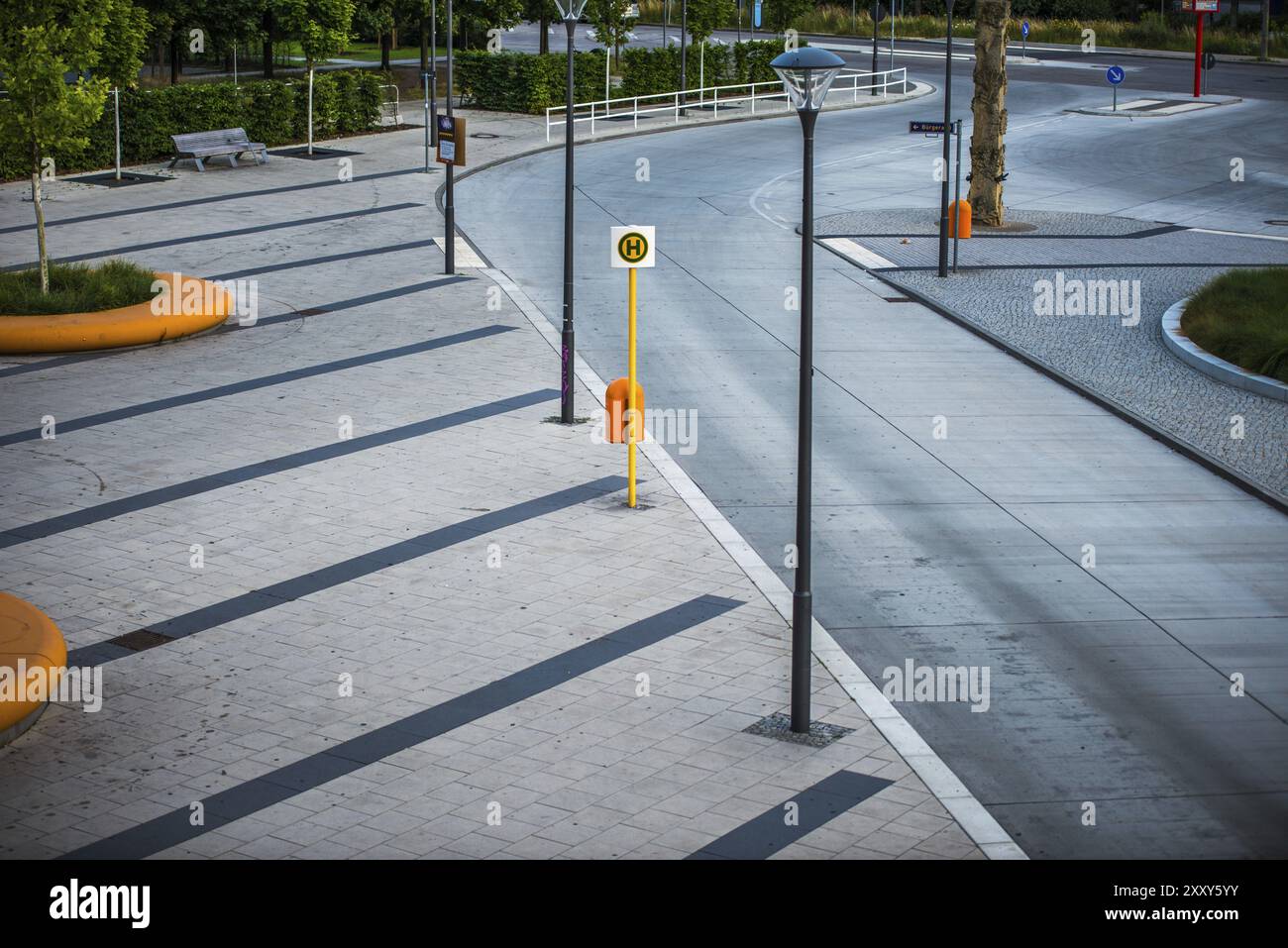 Winding road with yellow bus stop sign in Berlin Stock Photo - Alamy