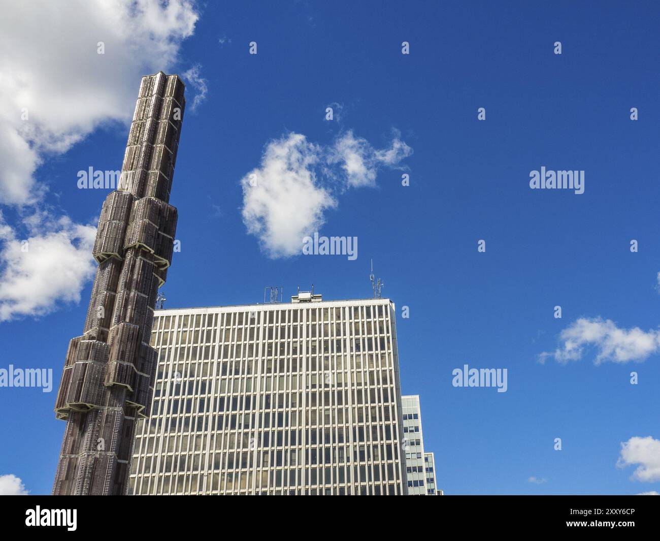 A skyscraper with vertical design next to a modern high-rise building ...
