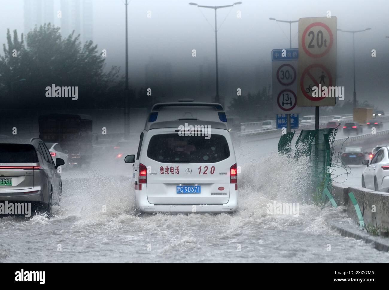 Beijing, China. 26th Aug, 2024. An ambulance wades through a ...