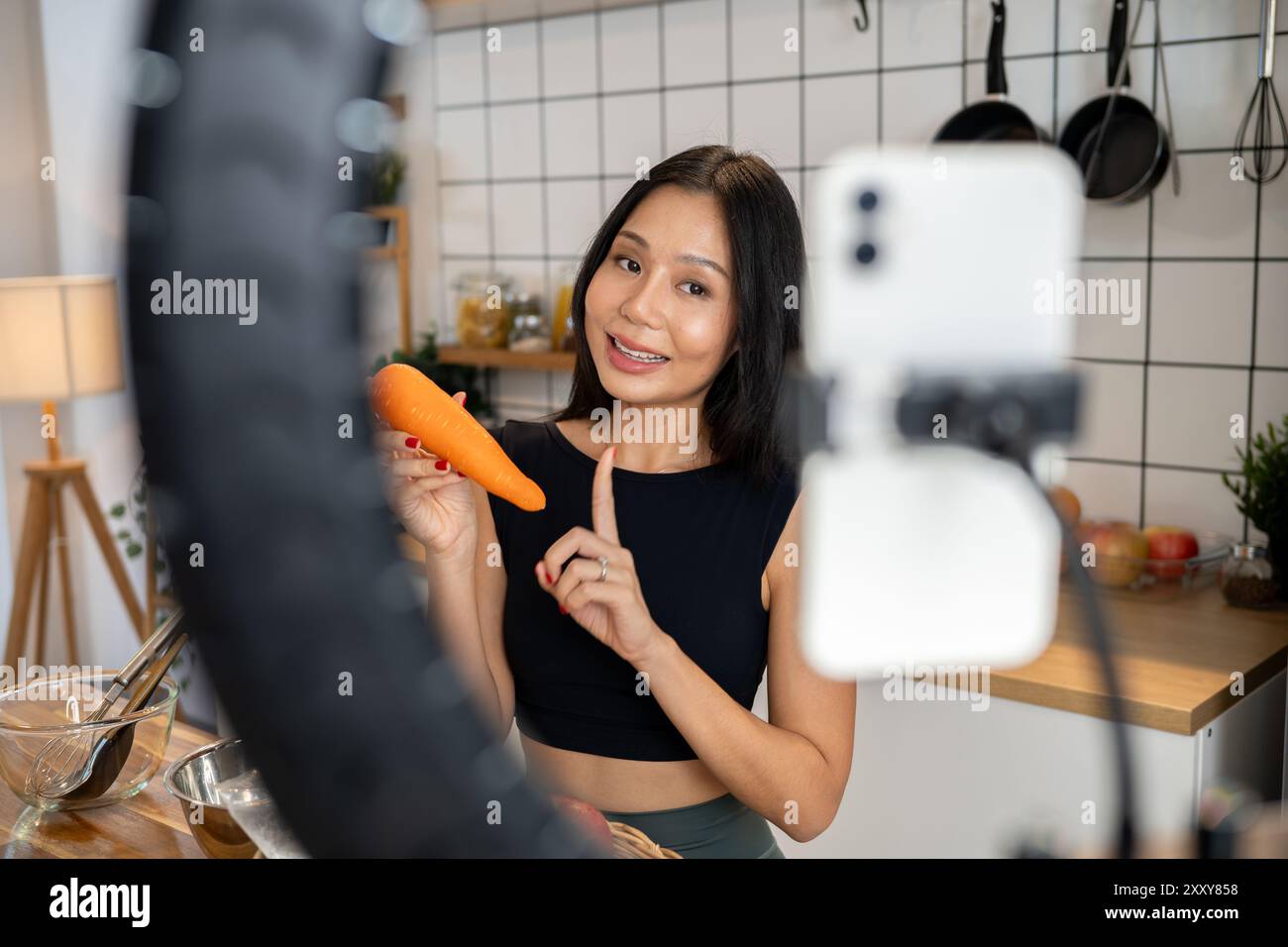 An attractive Asian female food blogger or content creator is cooking ...