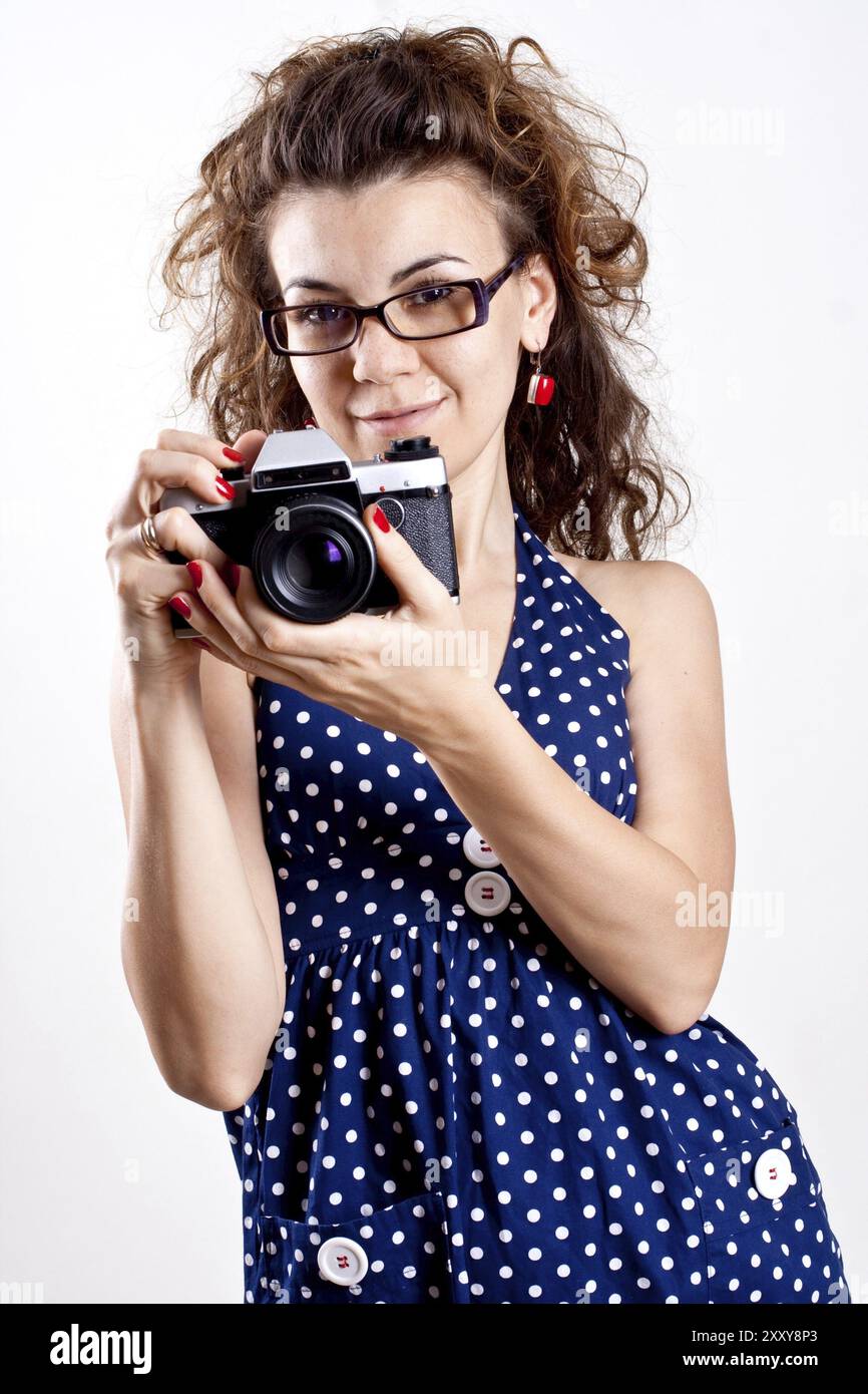 Beautiful woman in a blue polka dot dress with camera Stock Photo - Alamy