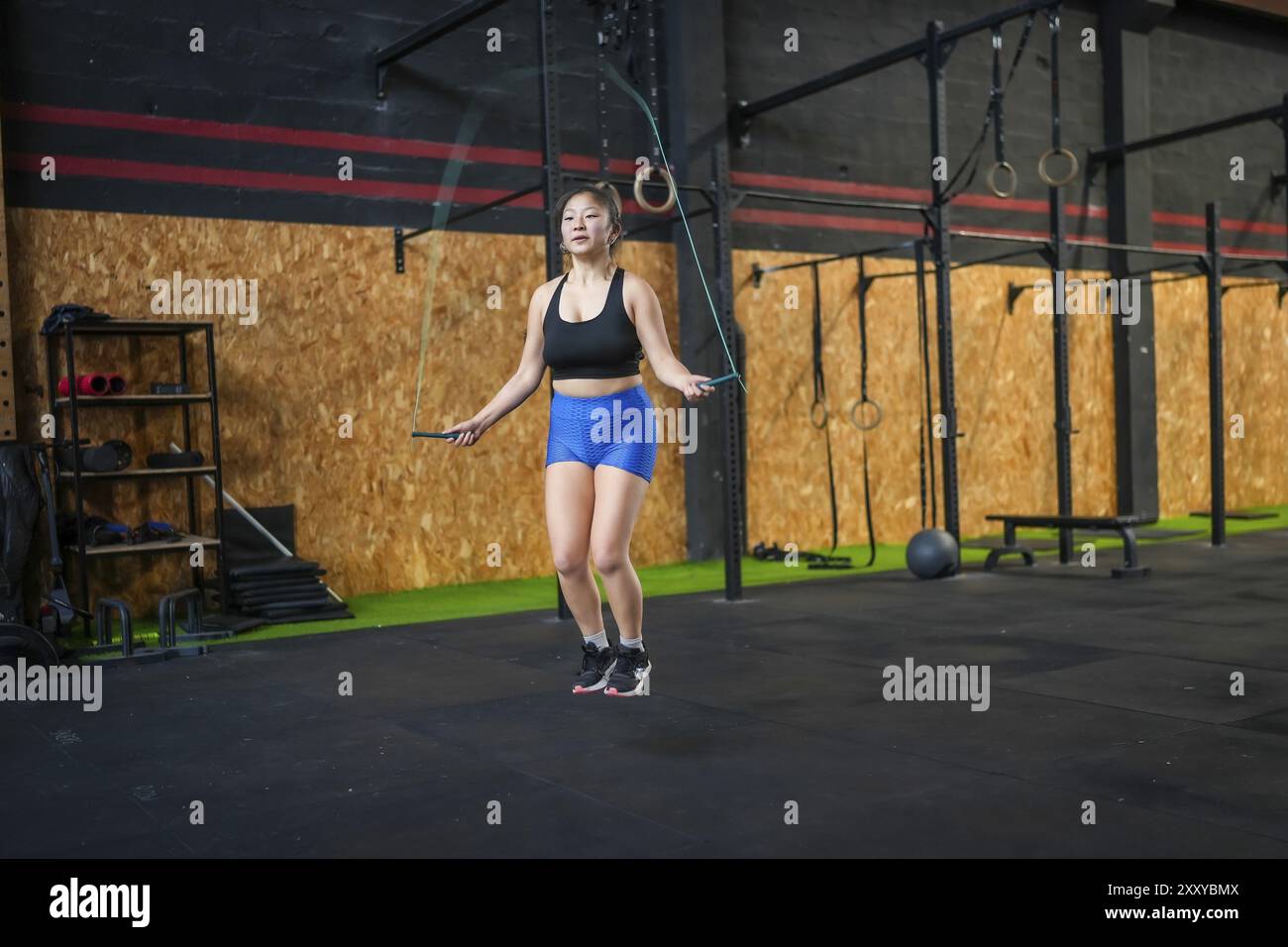 Full length photo of a Chinese sportive woman skipping rope alone in a ...