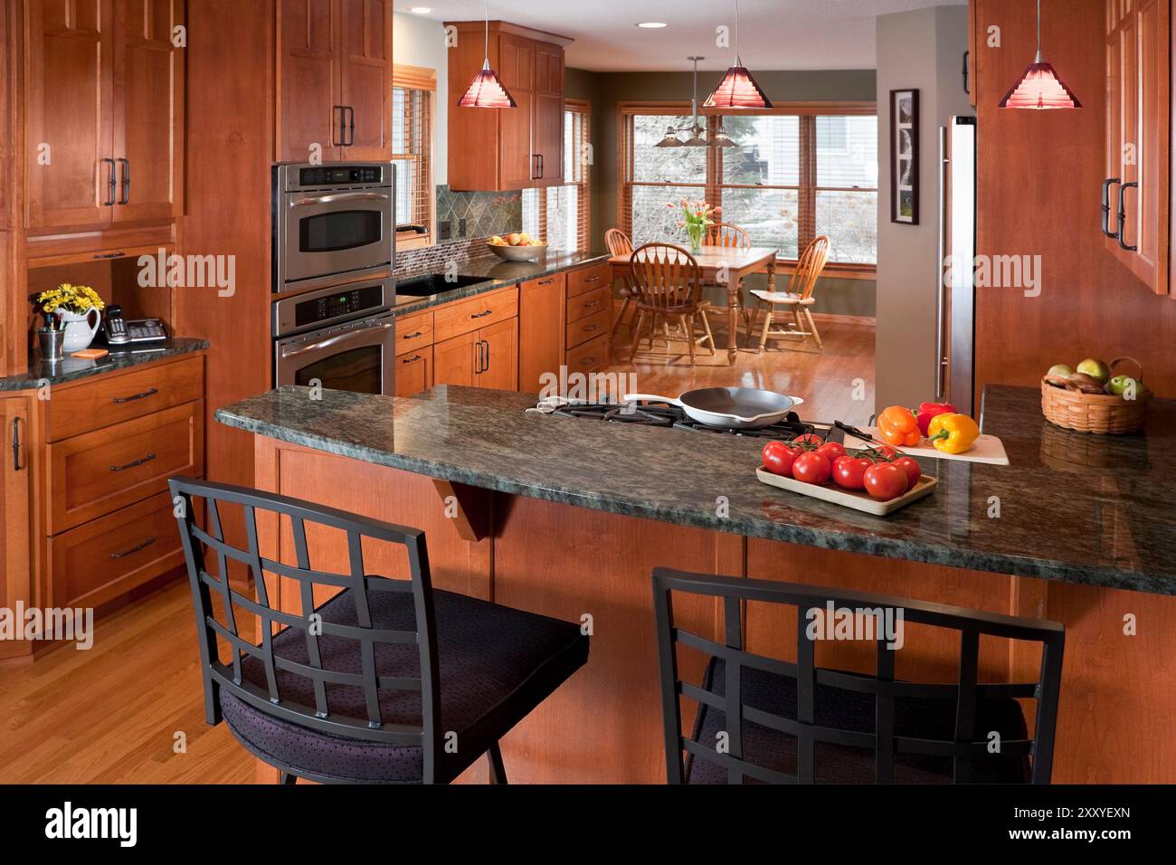 View over counter into kitchen with warm toned cabinets Stock Photo - Alamy