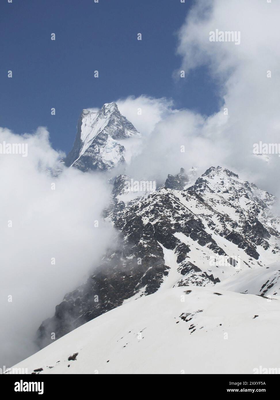 Peak of famous Machapuchare, Fish Tail mountain, surrounded by clouds ...