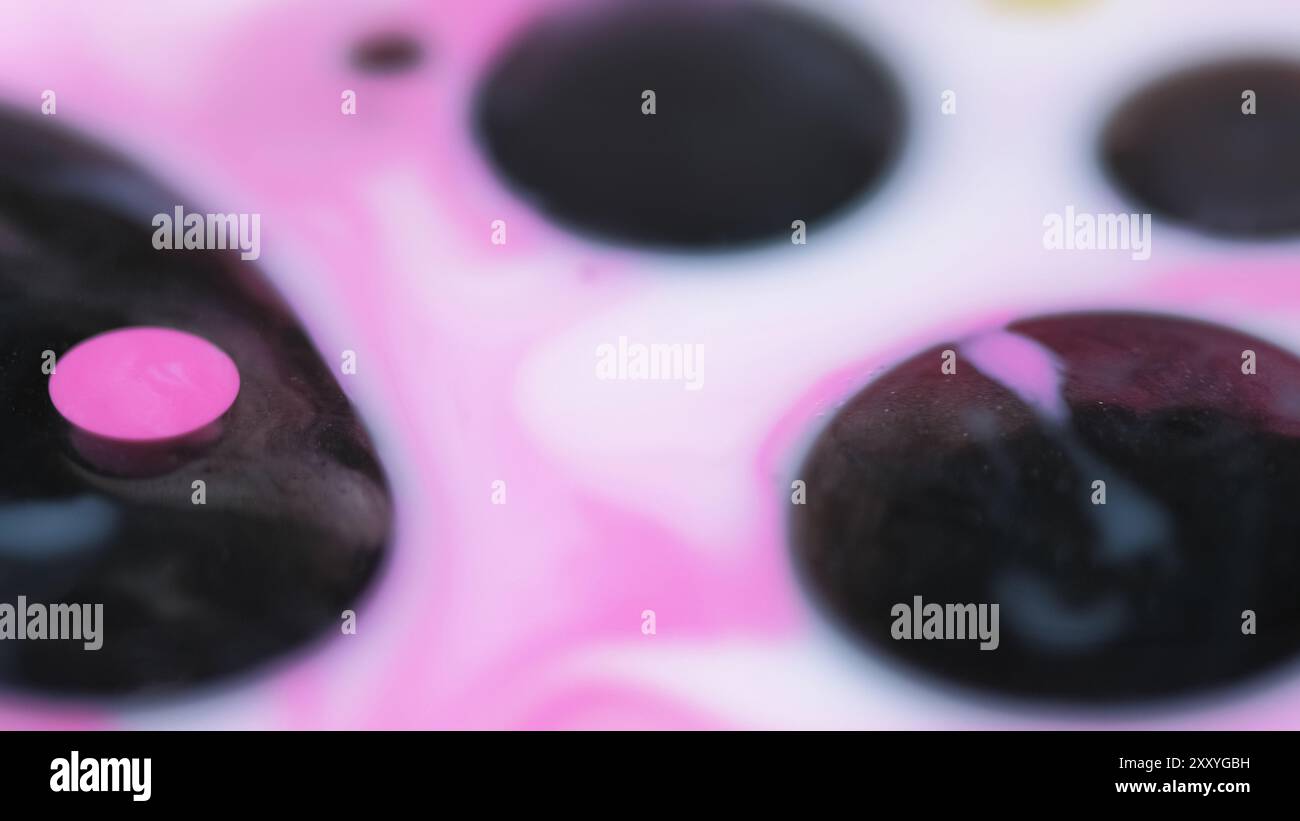 Ink bubbles. Fizzy liquid. Defocused black pink white color round ...