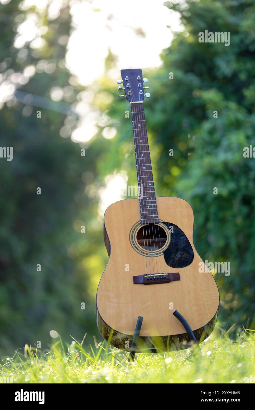 Acoustic guitar outdoors on greenery background. Concept of calm music ...