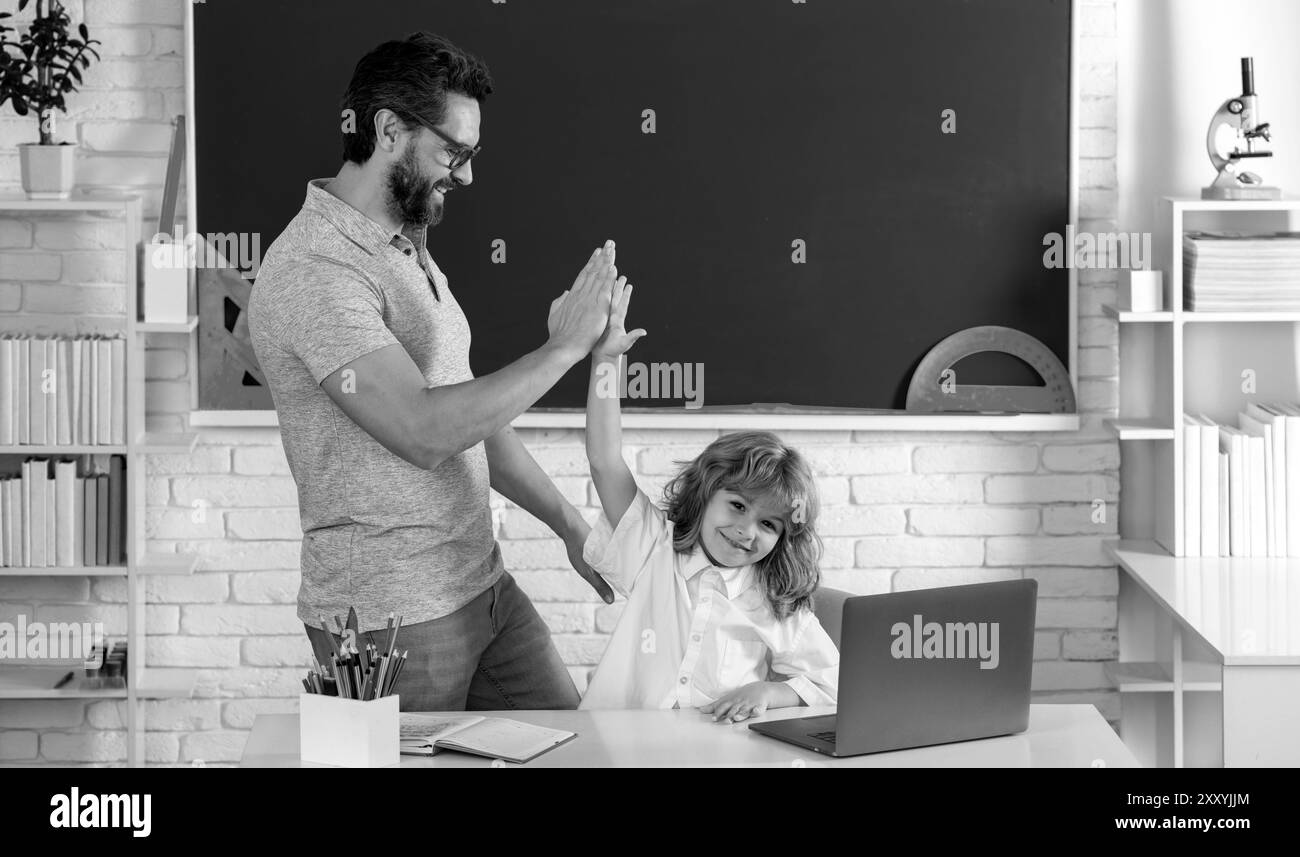School kid and teacher learning study in class. Teacher helping child ...