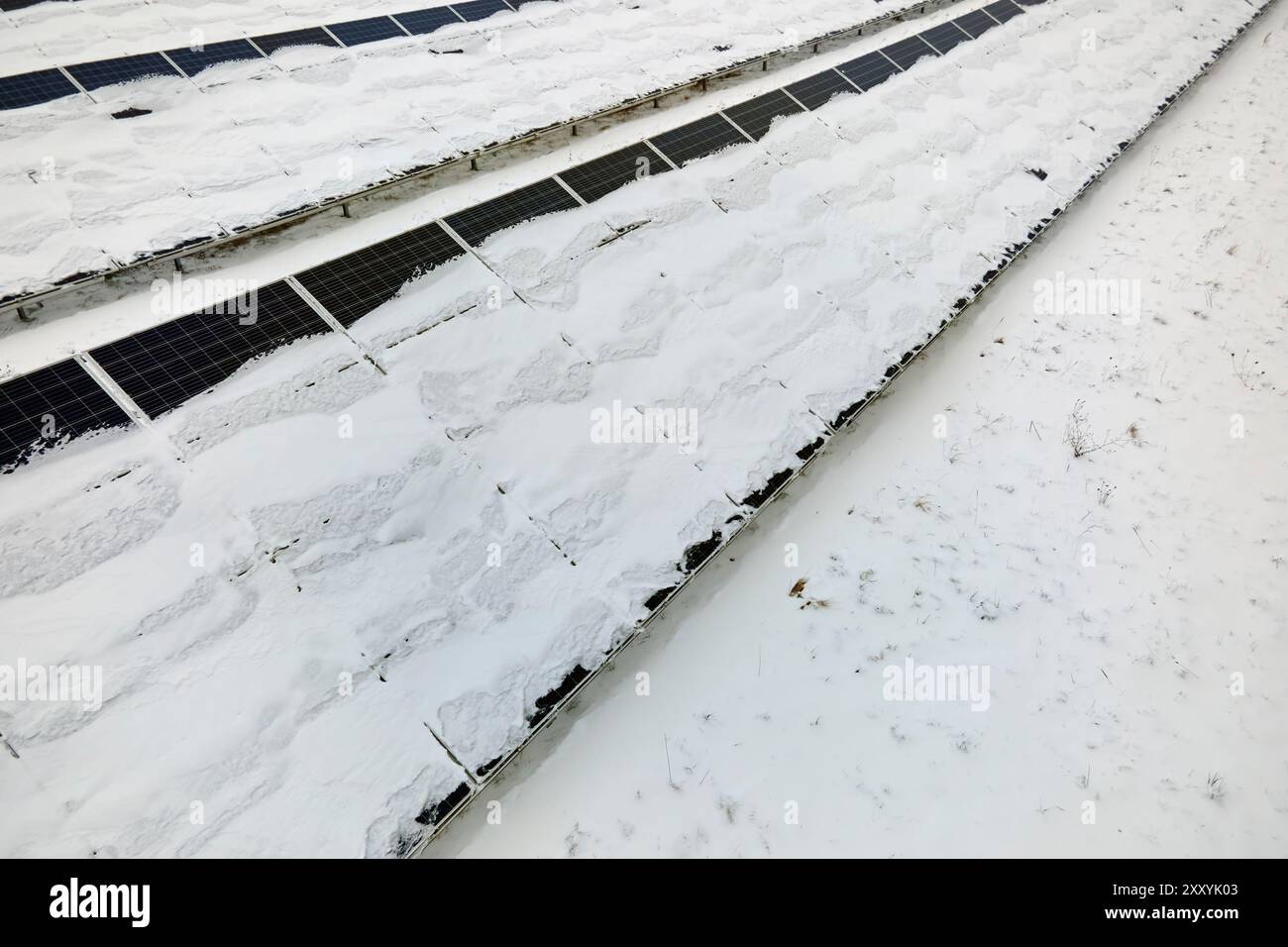 Aerial view of snow covered sustainable electric power plant with rows ...