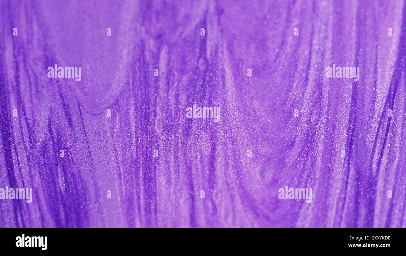 Glitter paint. Ink flow. Defocused purple color spill shiny liquid ...