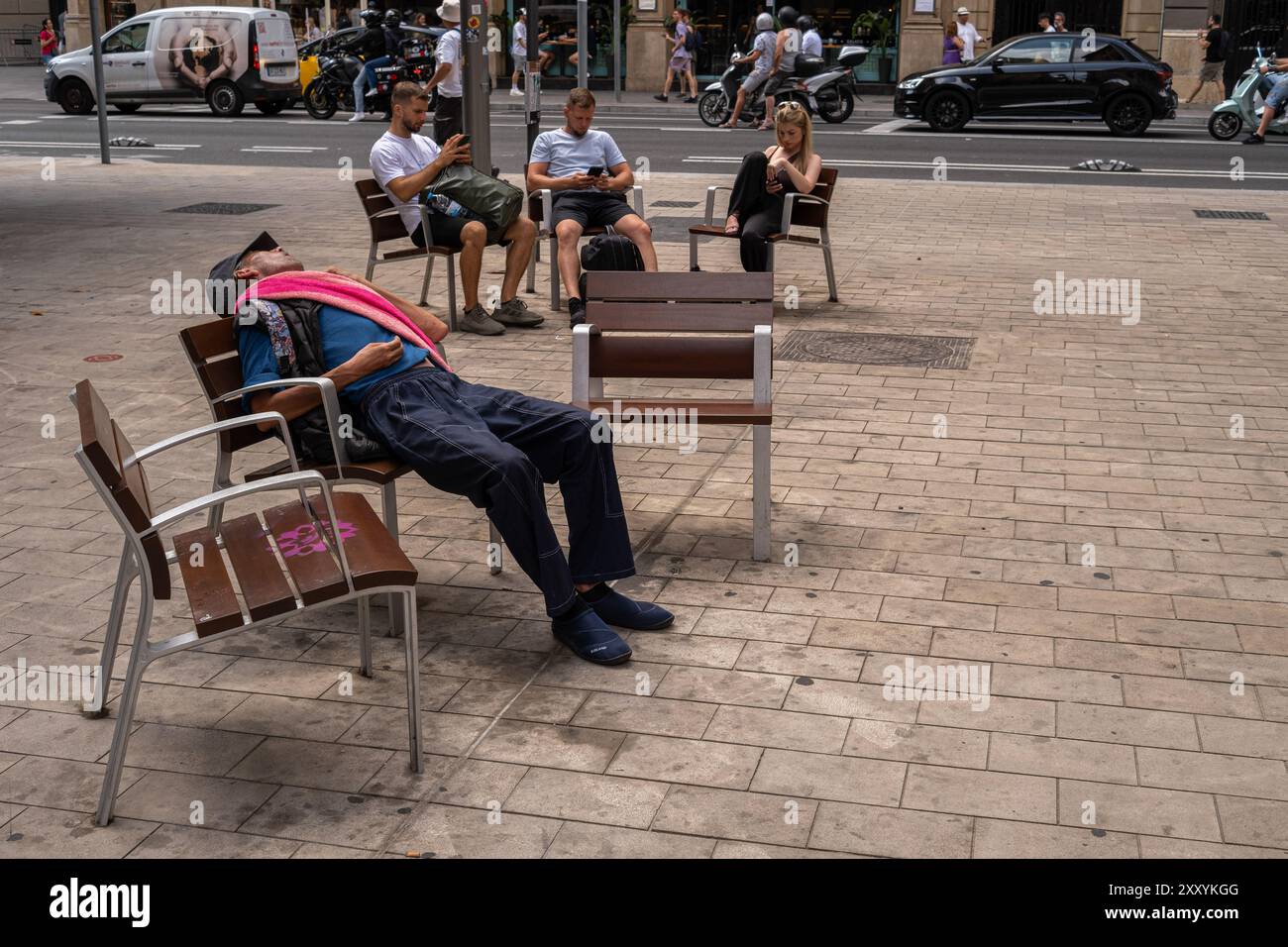 A person is seen sleeping in a rather exaggerated position on a public ...