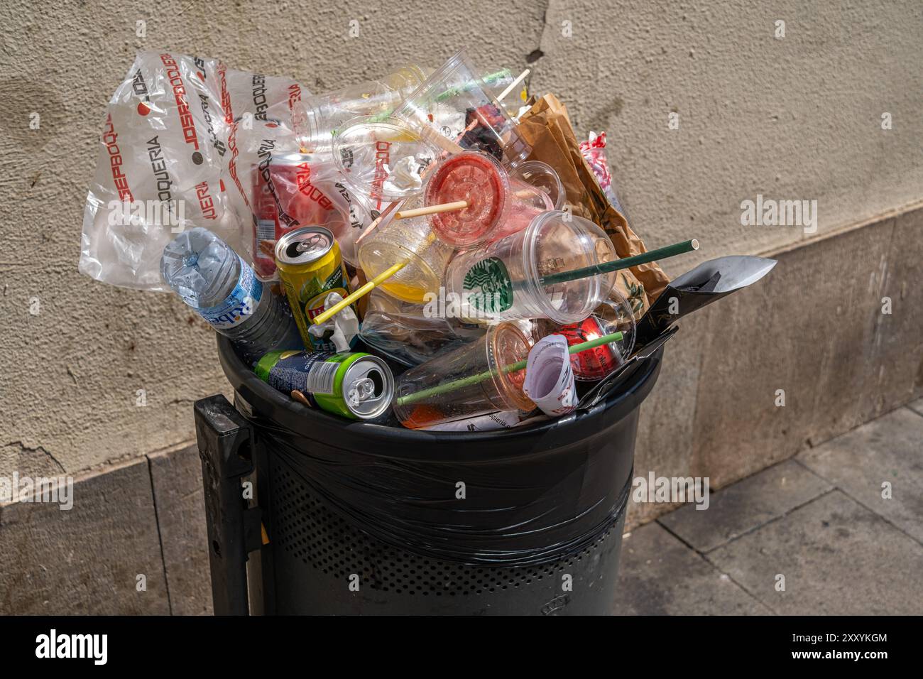 A trash can full of food scraps, cans, and soda cups is seen in the ...