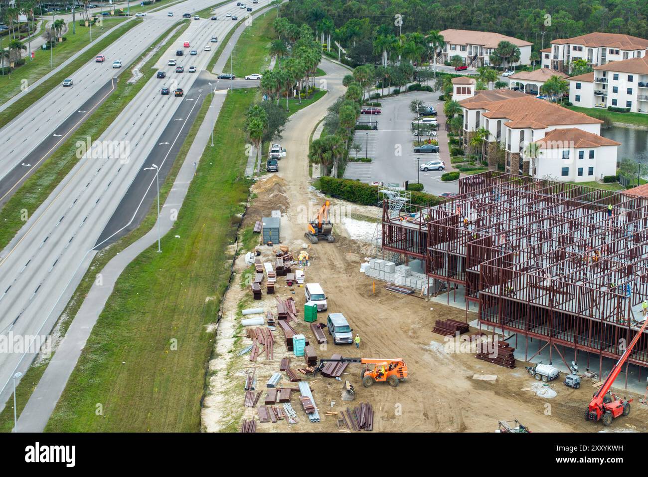 Construction site with hardhat workers assembling metal frame walls ...