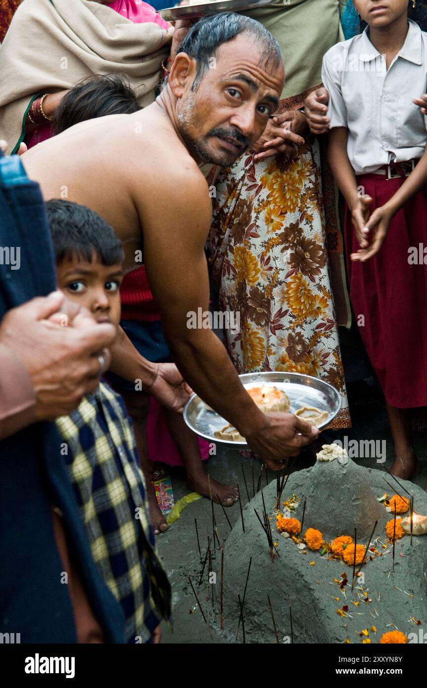 A Hindu man performing puja at the Gangasagar mela in West Bengal ...