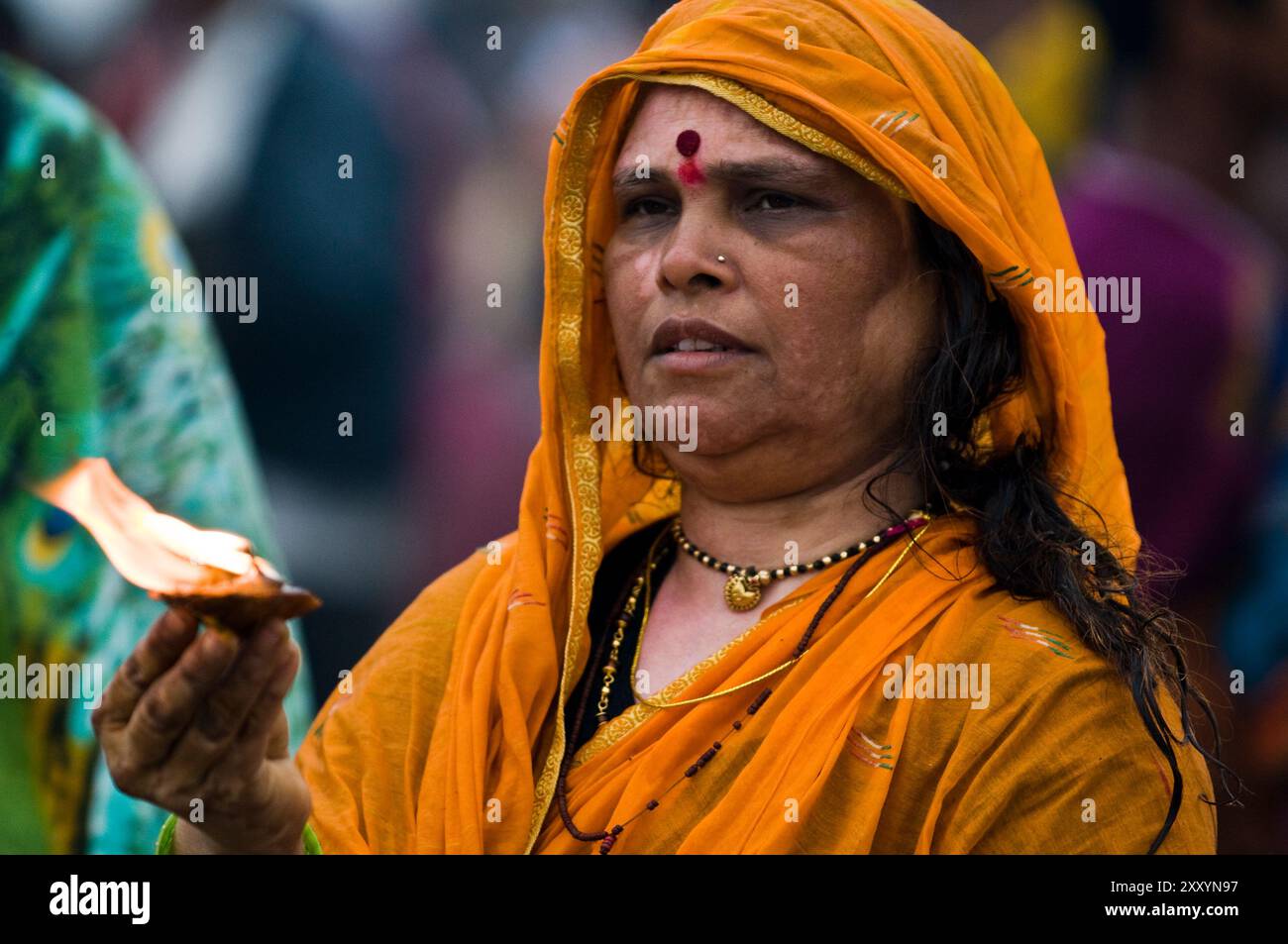 AHindu pilgrim performing puja at the Ganga river during the Ganasagar ...