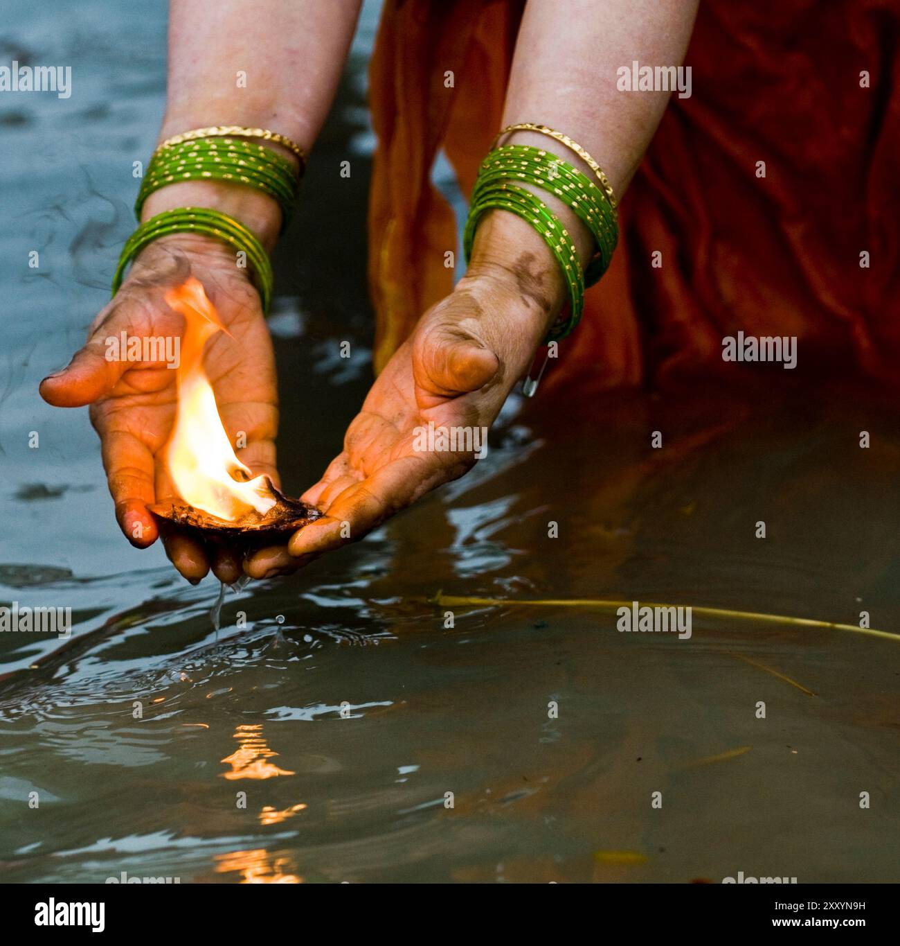 AHindu pilgrim performing puja at the Ganga river during the Ganasagar ...