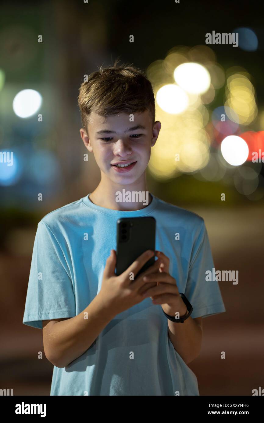 Portrait of positive happy teenager boy texting with his friend on ...