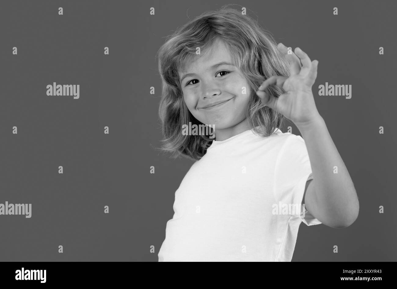 Portrait of cute smiling child with okay gesture, isolated studio ...