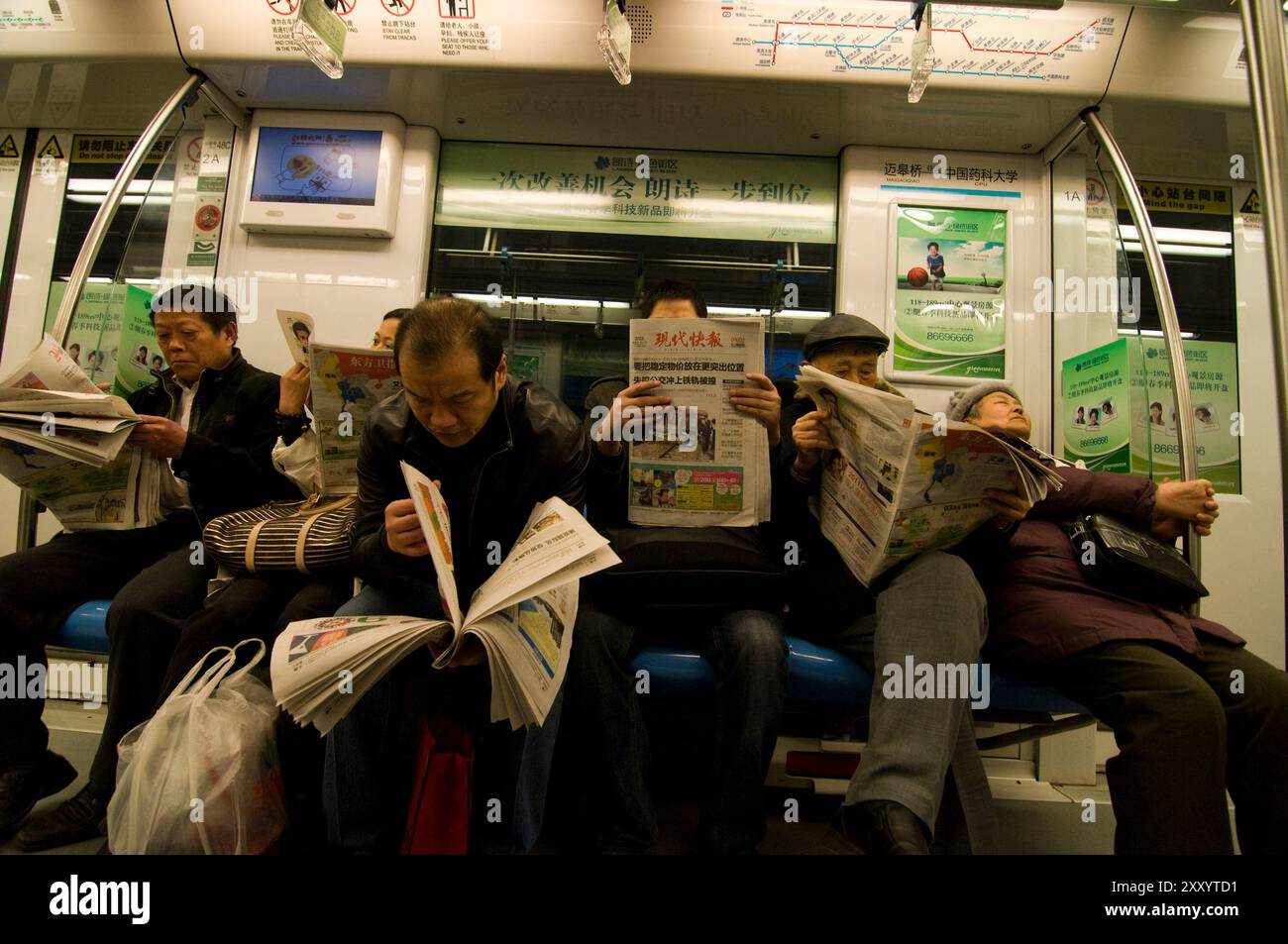 Passengers reading the morning newspaper while sitting in the metro ...