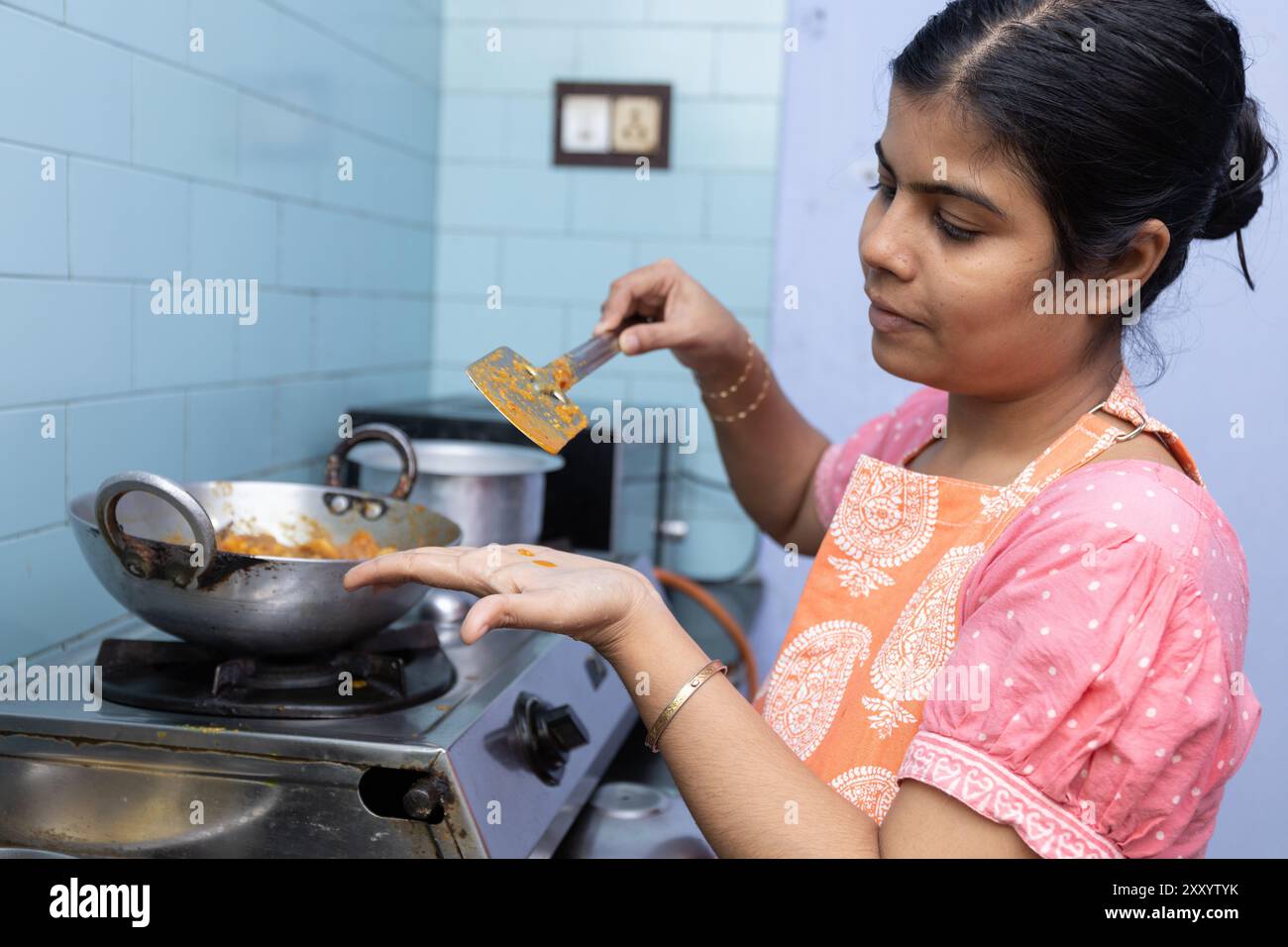 An Indian housewife of middle class family wearing cooking apron ...