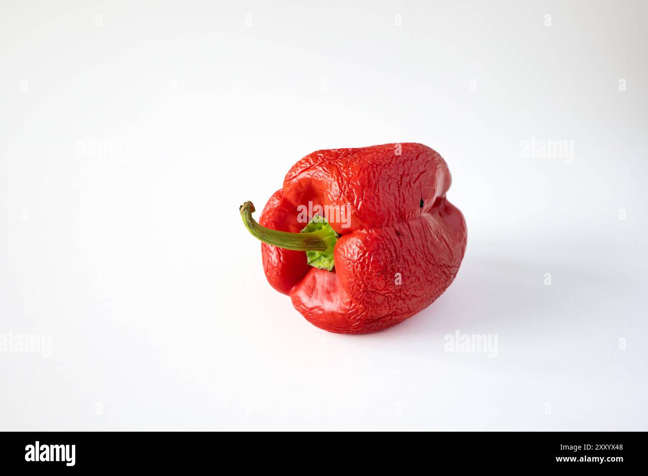 Red, spoiled, wrinkled or overripe bell pepper against white background ...