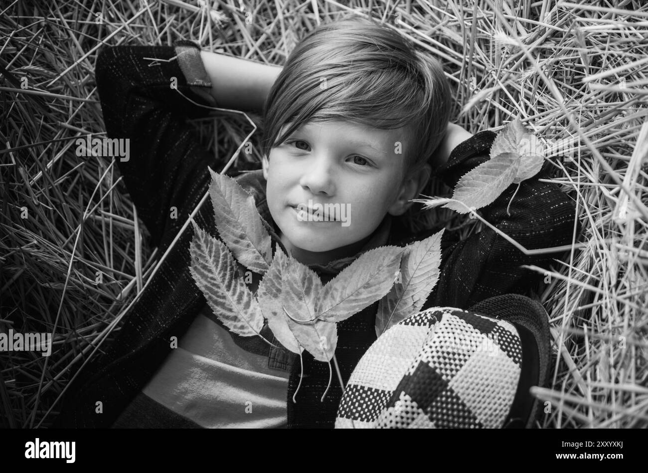 Boy lies on the hay. Autumn dream. Kid dreams on autumn nature ...