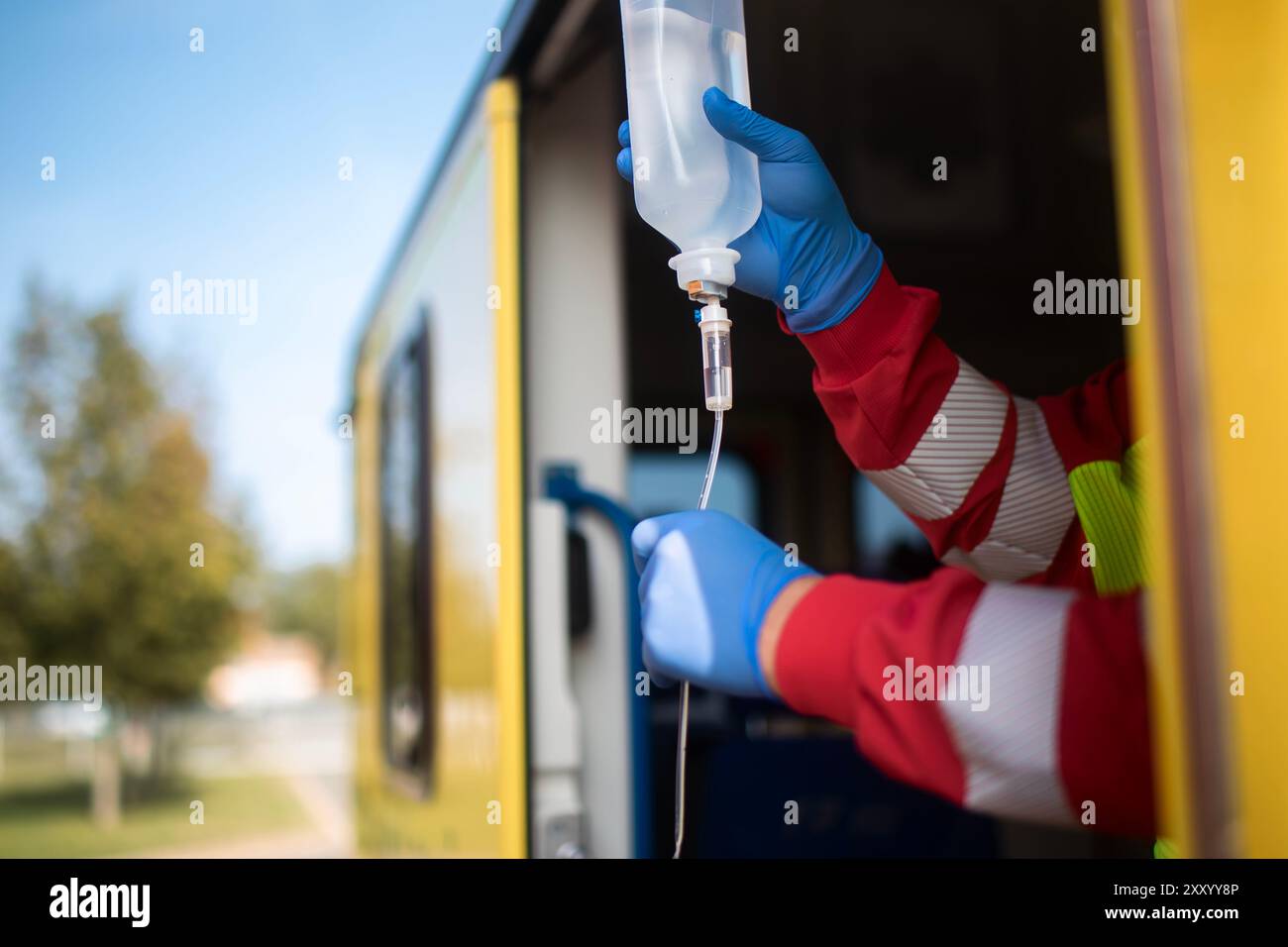 Close-up hand of paramedic holding IV drip in ambulance car of ...
