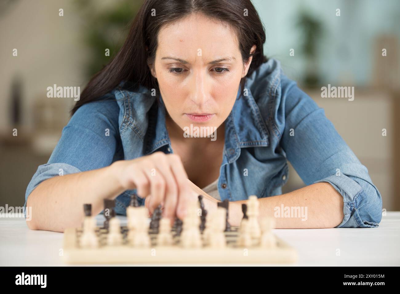 beautiful brunette woman playing chess Stock Photo - Alamy