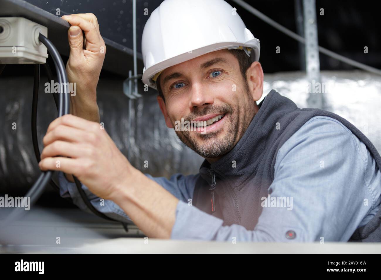 male worker installing mounting clips in a concrete ceiling Stock Photo ...