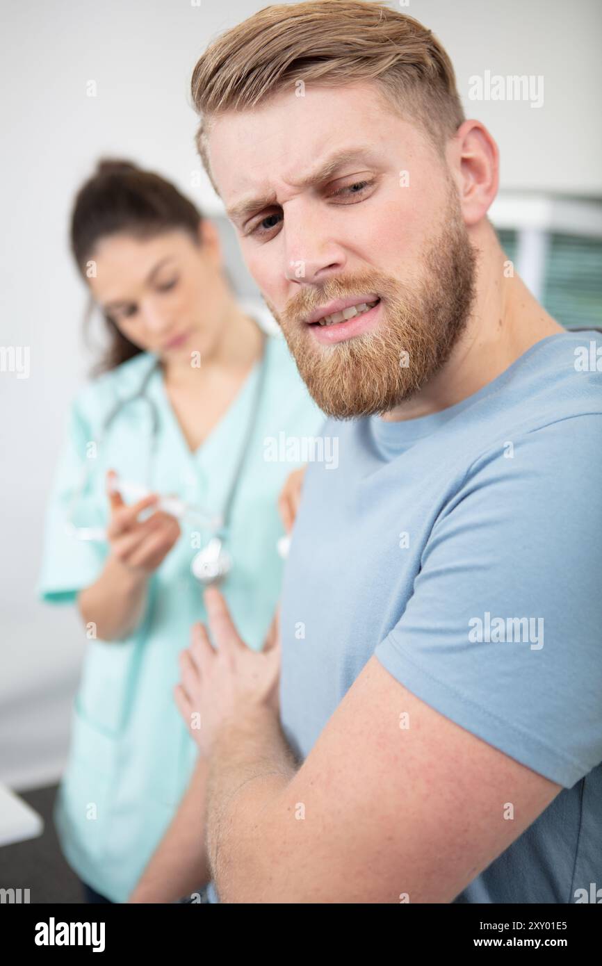 man looks away as nurse prepares syringe Stock Photo - Alamy