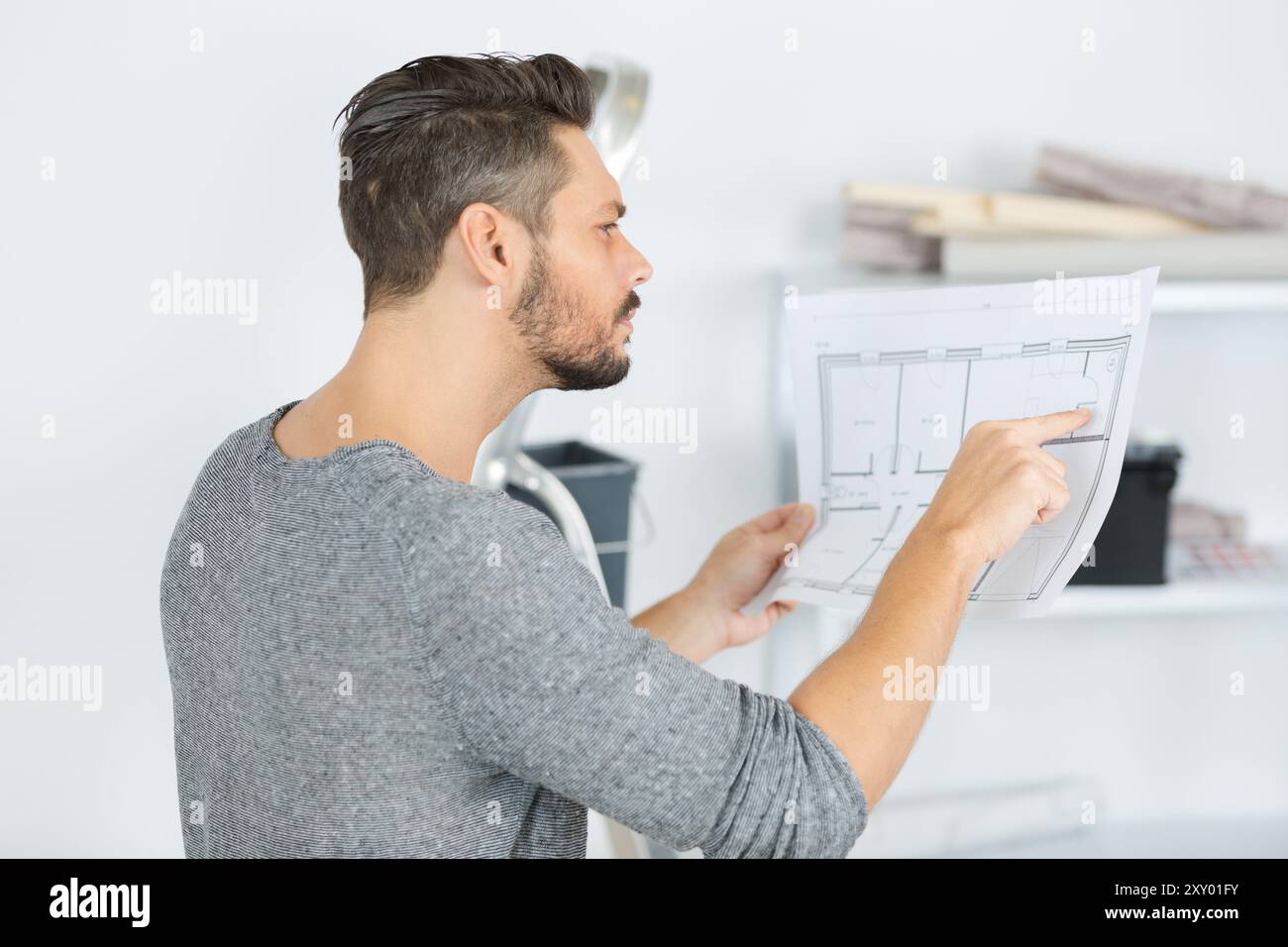 happy handsome man looking at house construction plan indoors Stock ...