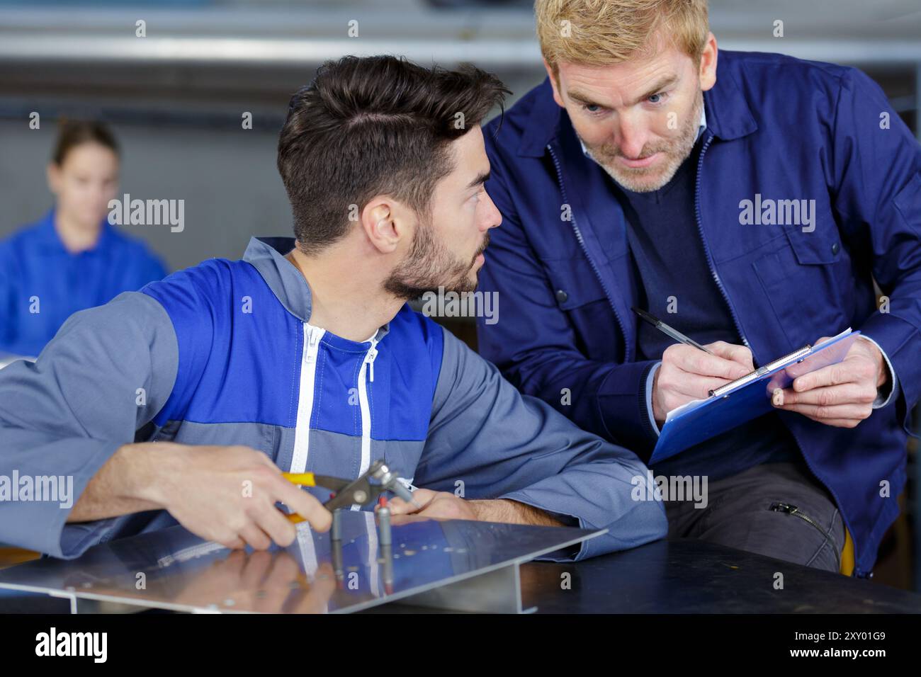 skilled mechanic and apprentice working together Stock Photo - Alamy