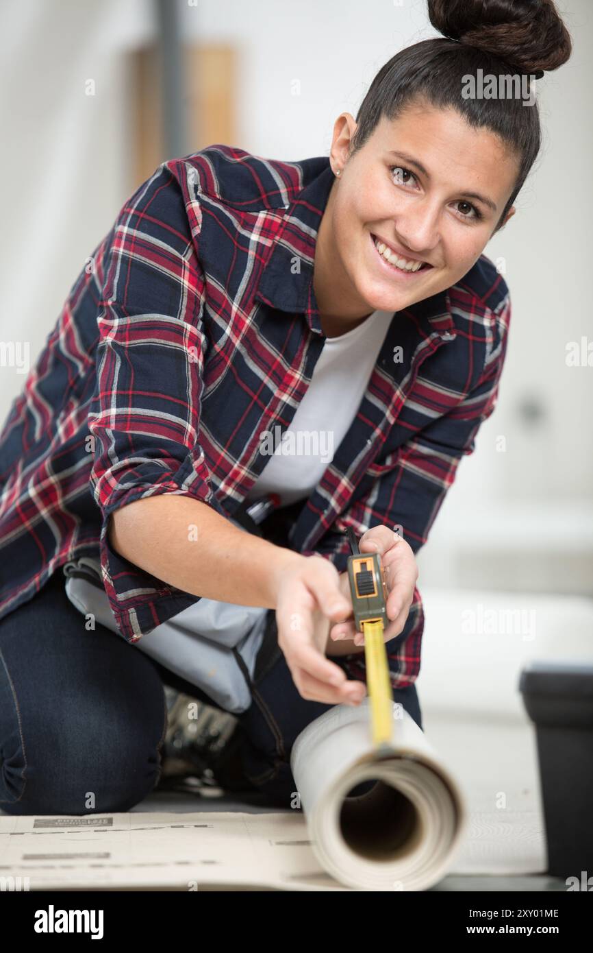 happy female worker measuring a piece of carpet Stock Photo - Alamy