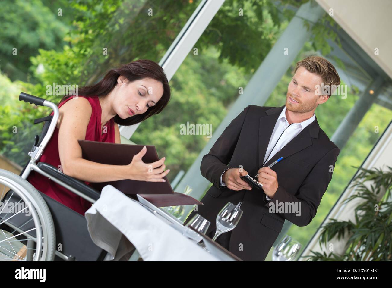 disabled customer giving male waiter her restaurant order Stock Photo ...