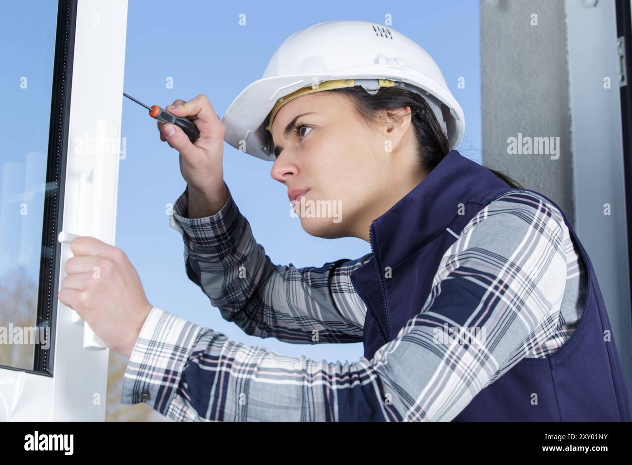 female window fitter using screwdriver Stock Photo - Alamy